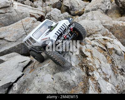 A toy car Jeep Wrangler on stones by the lake with a view of nuclear ...