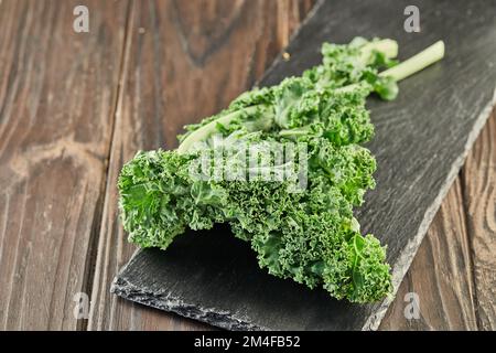 Curled lettuce on black stone on wooden background. Close up Stock ...