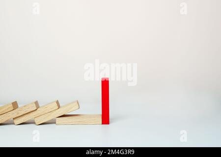 One red domino stands, and other wooden dominoes fall in a row. Chain ...