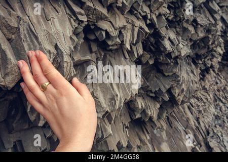 Close up woman touching basalt rock concept photo Stock Photo - Alamy