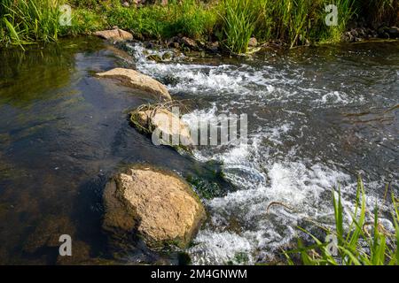 A Small waterfall next to a rock through a small stream. High quality ...