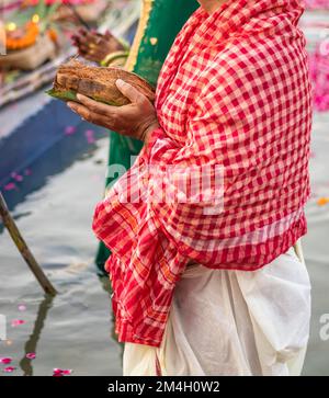 man devotee with religious offerings for sun god during Chhath festival ...