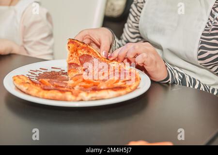 close up. small participants of the master class eat pizza . cooking ...