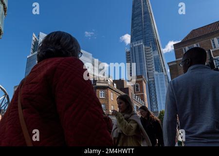 Pedestrians crossing Bedale Street by Borough market. Part of The Shard ...