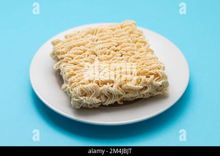 dry fresh noodle cubes on white small dish Stock Photo - Alamy