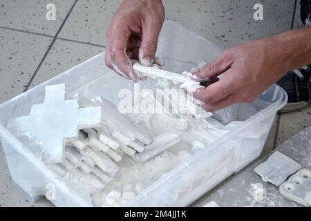 Male worker sorts through models in hands, lying in box and covered ...