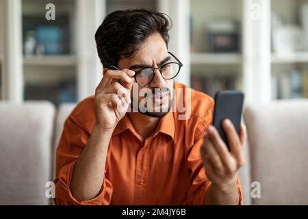 Unhappy arab man feeling bad, blowing his nose at home Stock Photo - Alamy