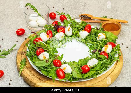 Charcuterie wreath made with mozzarella, cherry tomatoes and arugula ...