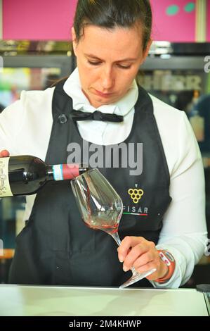 A closeup view of a female wine steward pouring red wine Stock Photo ...