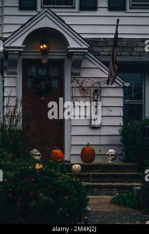 Many colorful Halloween decorations, skeletons, scarecrows at driveway ...