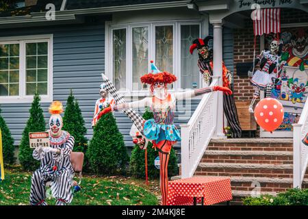 Many colorful Halloween decorations, skeletons, scarecrows at driveway ...