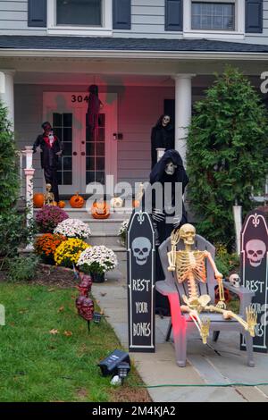 Many colorful Halloween decorations, skeletons, scarecrows at driveway ...