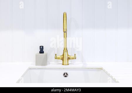 Stylish kitchen counter with rose gold furnishing including faucet and ...