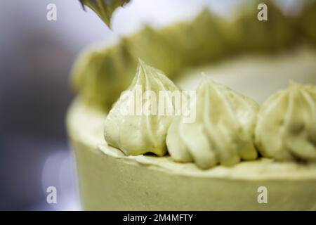 pastry chef designer making swirls with piping bag pistachio cream ...