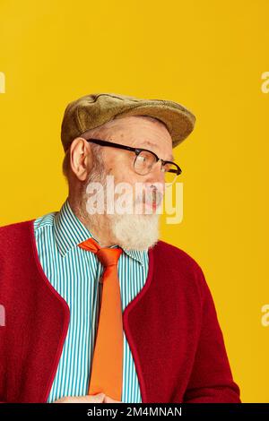 Senior male in a cute yellow outfit with a contemplating pose in front ...