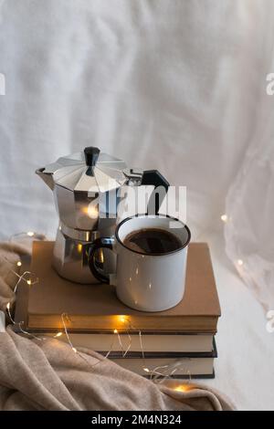 A moka pot end a cup of coffee in a cozy holiday environment. Enjoying ...