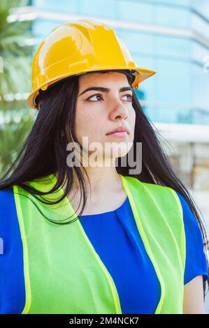 young caucasian venezuelan female engineer, wearing protective helmet ...