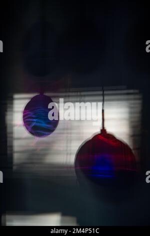 Glass hanging lights forming a colourful interesting shadow on a wall ...
