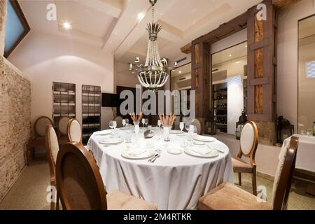 Dining room of a restaurant with oval tables with tablecloths and ...