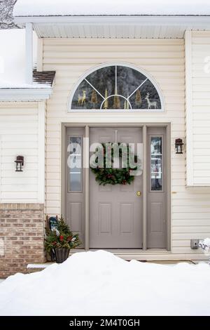 Front door with Christmas wreath and snow, horizontal Stock Photo - Alamy