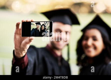 Look who just graduated. two students taking a selfie together on ...