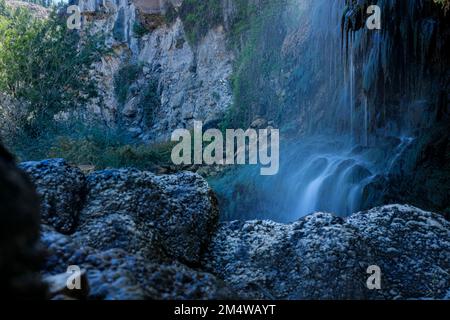 Chindia cascade, waterfall pouring over the cliff, backlit, with bird ...