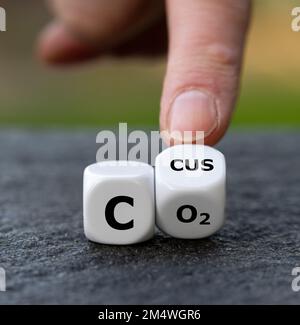 Symbol for carbon capture, utilization and storage (CCUS). Hand turns ...