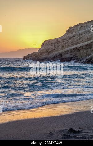 Greece, Crete, Matala, Matala Beach and cliffside caves at sunset Stock ...