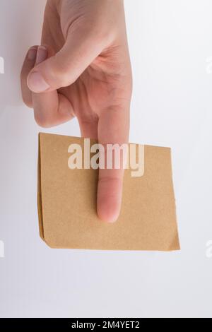 Hand holding a brown color sheet of paper on a white background Stock ...