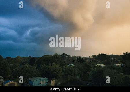 Dramatic cloudscape over green woody hills and creek, Danube river ...