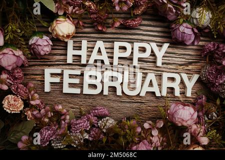 Happy February alphabet letters with flowers frame on wooden background ...