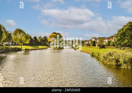 River or a lake surrounded by rural houses and trees Stock Photo - Alamy