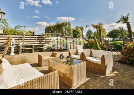 an outdoor patio area with wickers, chairs and table in the foreground ...