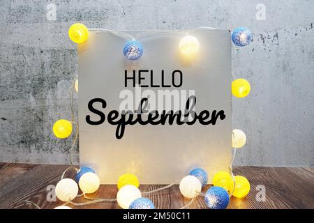 Welcome September text message with LED cotton balls decorate on wooden ...