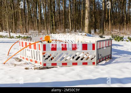 A closeup shot of a road blocking signs on a snowy field, with an ...