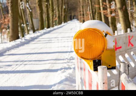 A closeup shot of a road blocking signs on a snowy field, with an ...