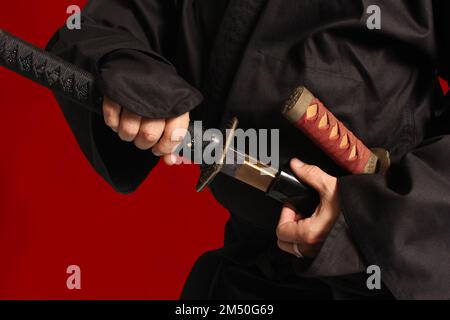 Man Removing Japanese Katana Sword From Scabbard Stock Photo - Alamy