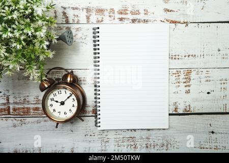 Notebook with blank pages withh alarm clock and floweron wooden ...