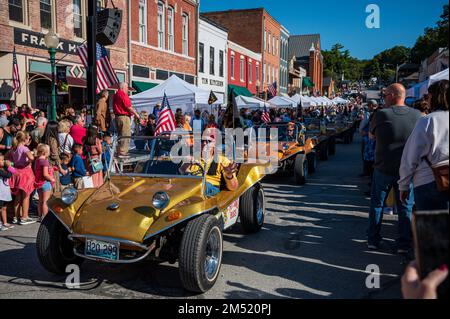 The Shriners in gold dune buggy in small town during Applefest parade ...