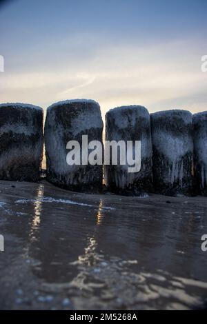 Wooden groynes with blue water and red sunset. Long exposure Stock ...