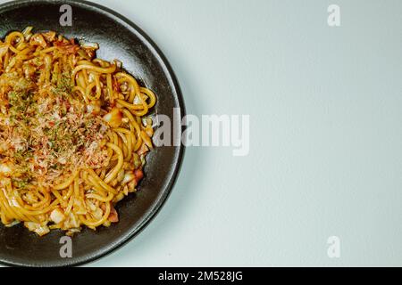 Delicious yakisoba dish on a black plate Stock Photo - Alamy