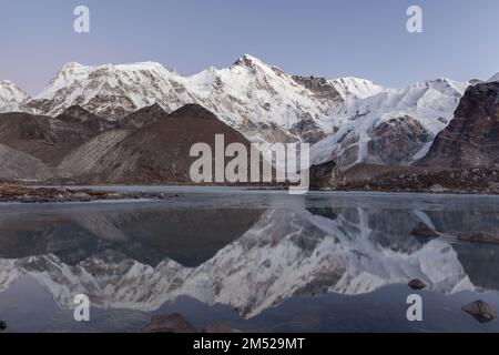 Beautiful mountain Cho Oyu and gray moraine lake covered with ice ...