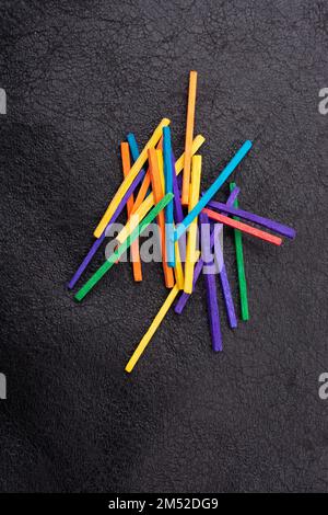 Beautiful coloured wooden sticks for creativity on black background ...