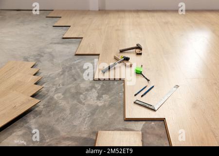Worker Installing Interlocking laminate floor, home renovation Stock ...