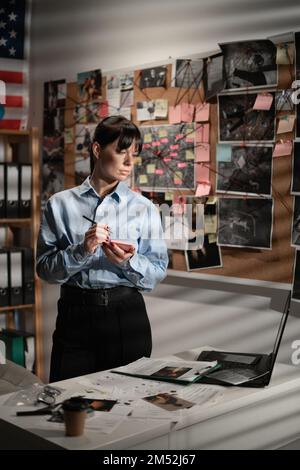 Private detective standing in working overtime in agency office ...