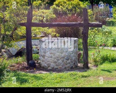 old well made of bricks and wooden pole Stock Photo - Alamy