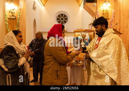 Catholic priest is seen giving holy communion inside a church during ...