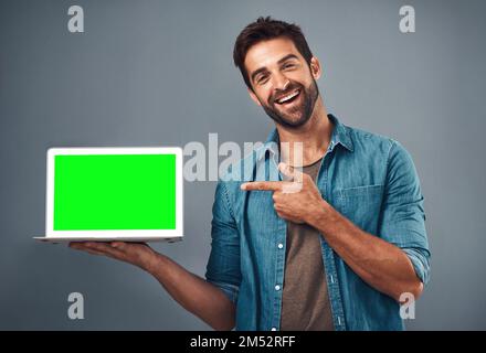 Catch me online. Studio shot of a handsome young man using a digital ...