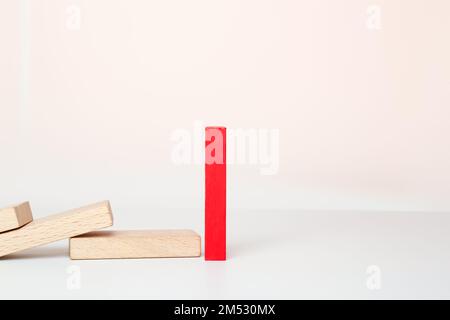 One domino stands, and other wooden dominoes fall in a row. Chain ...