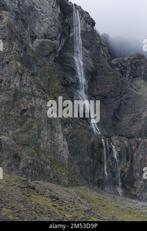 Cirque de Gavarnie with big waterfall and small person at massive high ...